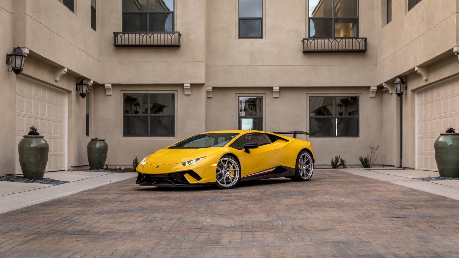 Yellow Lamborghini Huracán Supercar in Modern Courtyard Scene - backiee