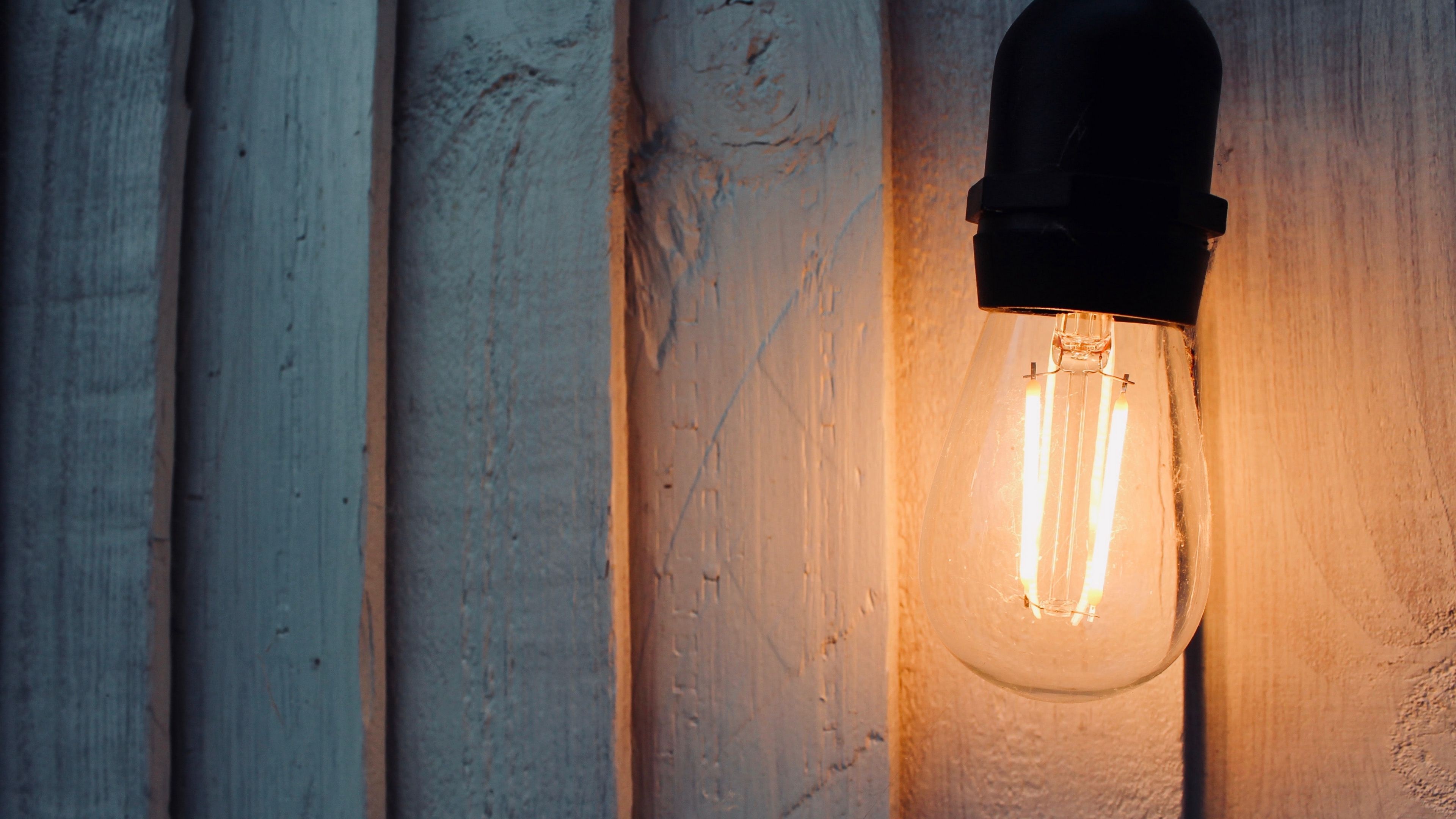 Warm Edison Glow on Rustic Planks in Technic Still Life 4K - backiee