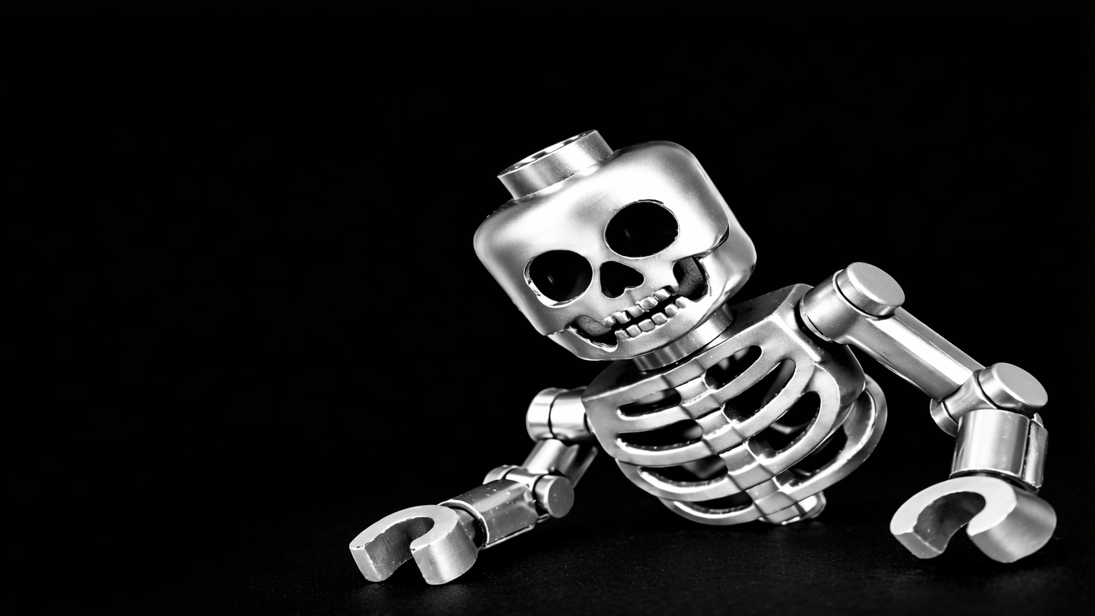 Shiny Lego Skeleton Strikes a Cheeky Pose on Deep Black - backiee