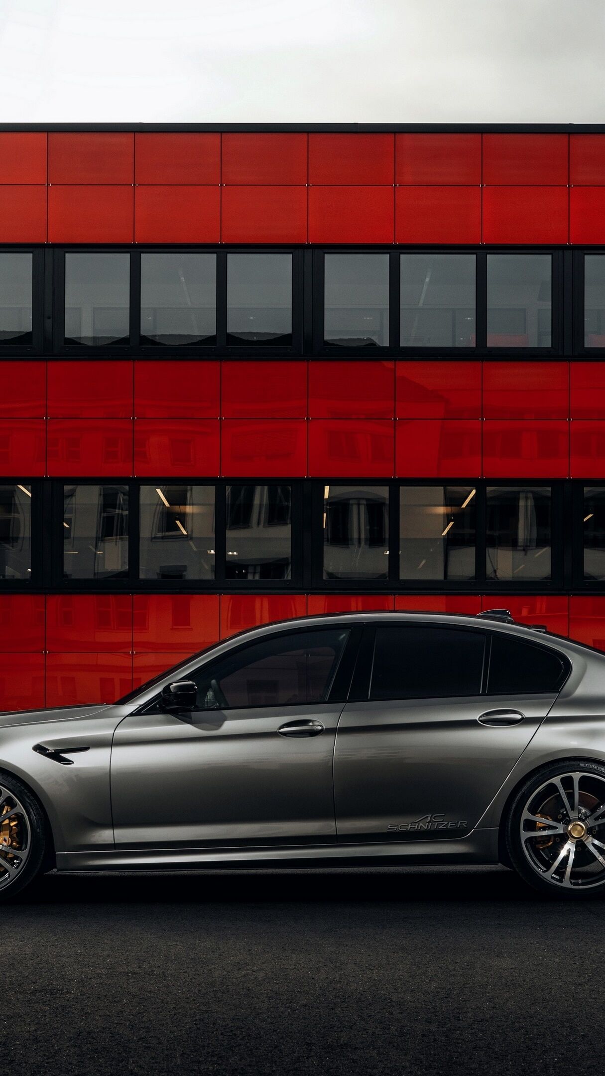 BMW M5 Side Profile Against Bold Red Modern Architecture - backiee