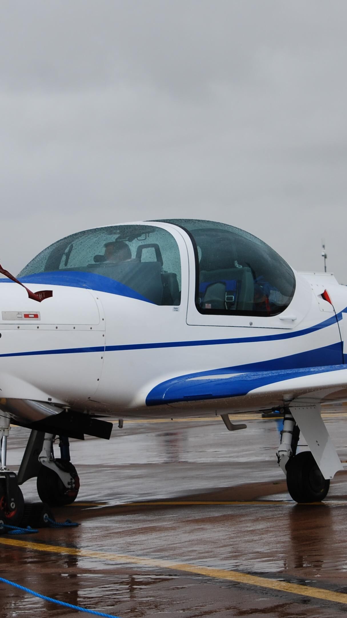Grob G 120TP Trainer Aircraft on Rainy Airfield in 4K - backiee