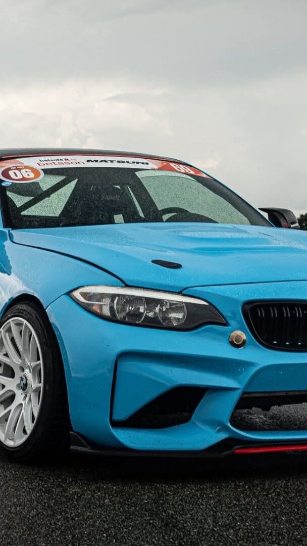 Sleek Blue BMW on a Wet Track - backiee